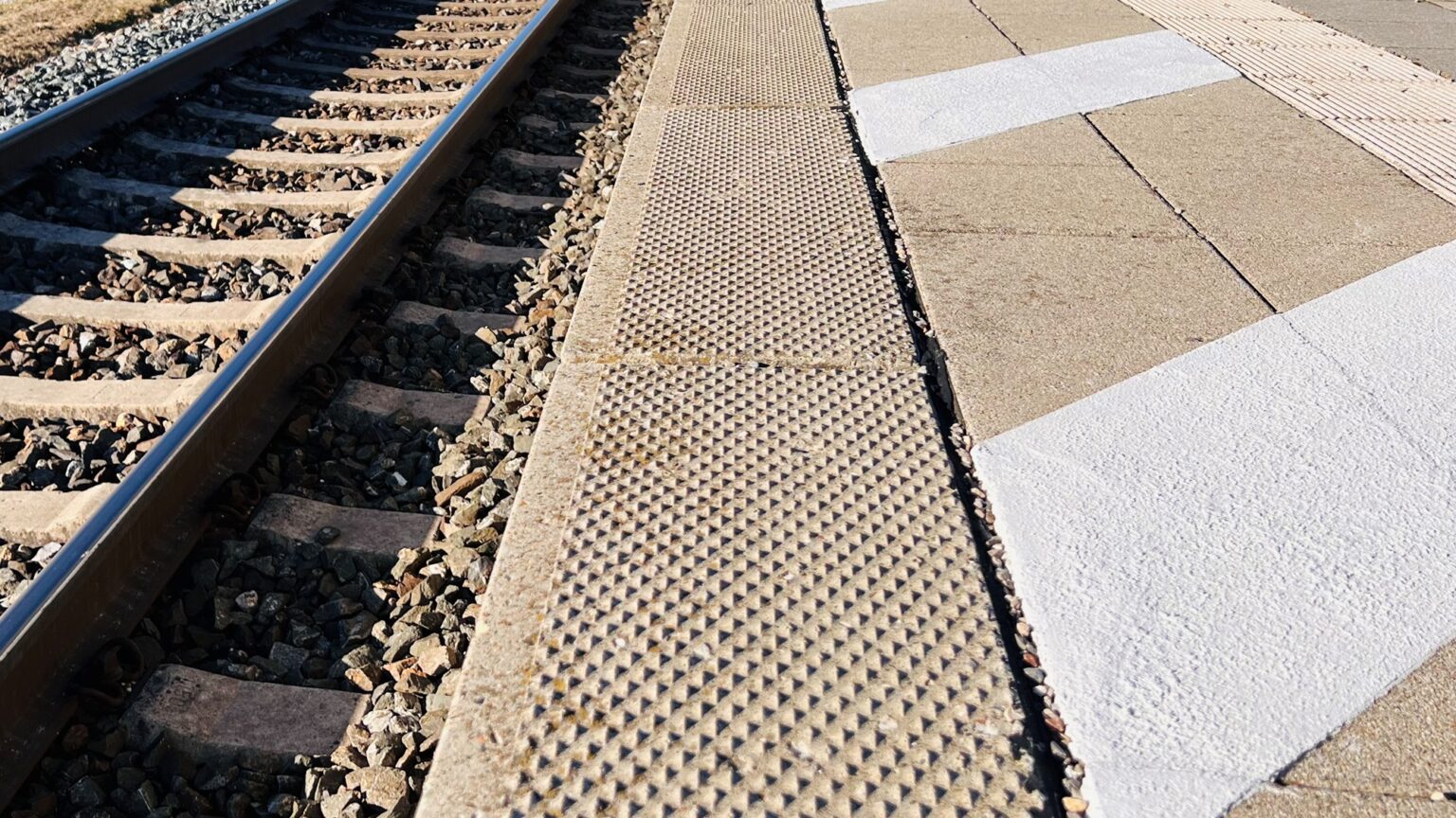 Mann sitzt auf Bahnsteigkante und wird von Zug erfasst – Bahnblogstelle